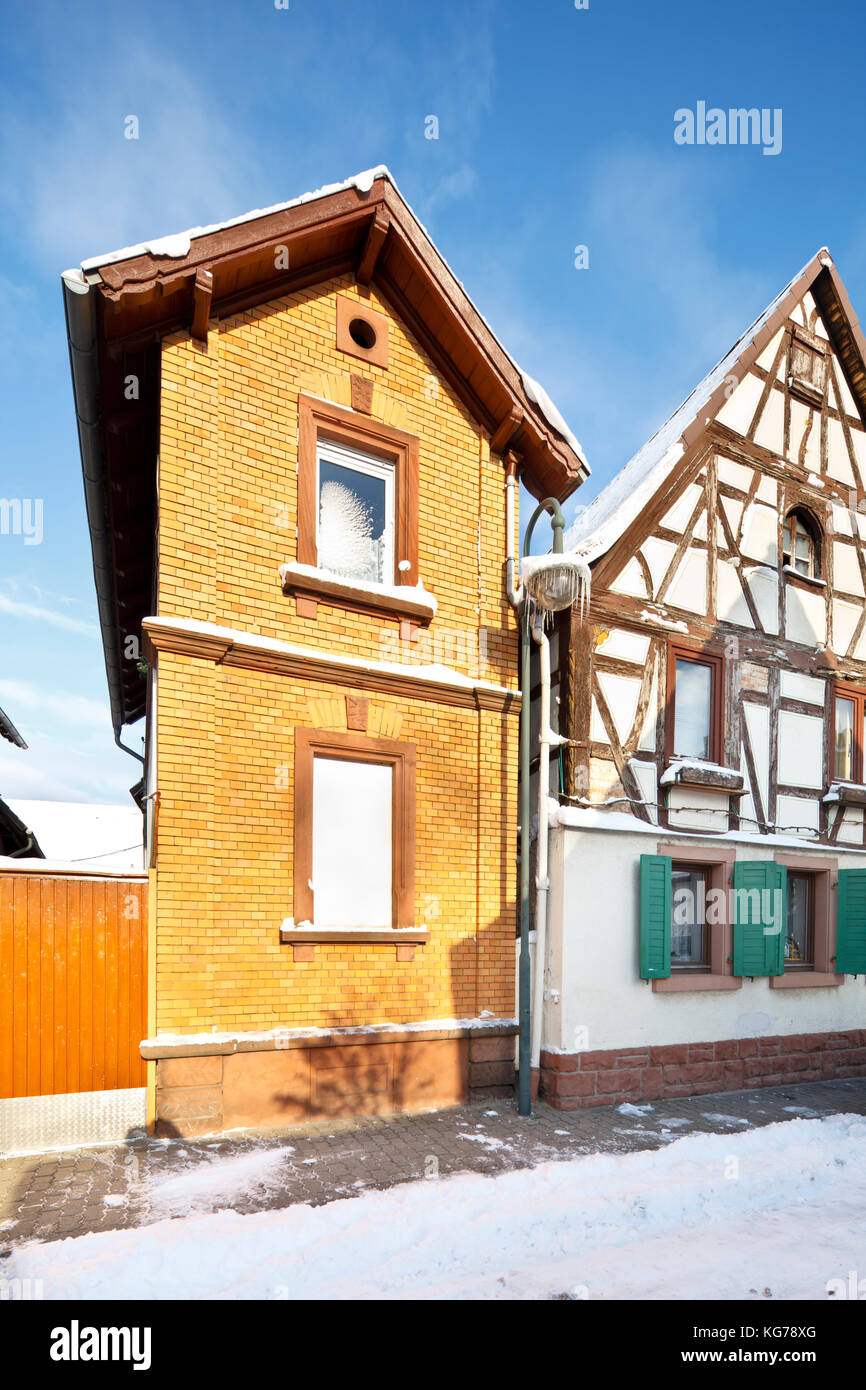 A very narrow house next to a half-timbered house in a small German ...