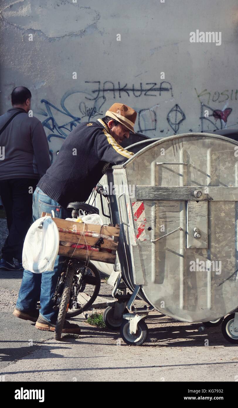 Poor man digging out of garbage Stock Photo - Alamy