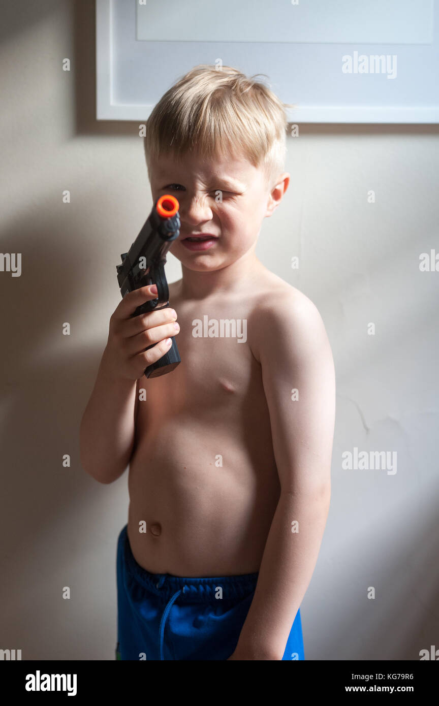 Little boy posing with gun Stock Photo - Alamy