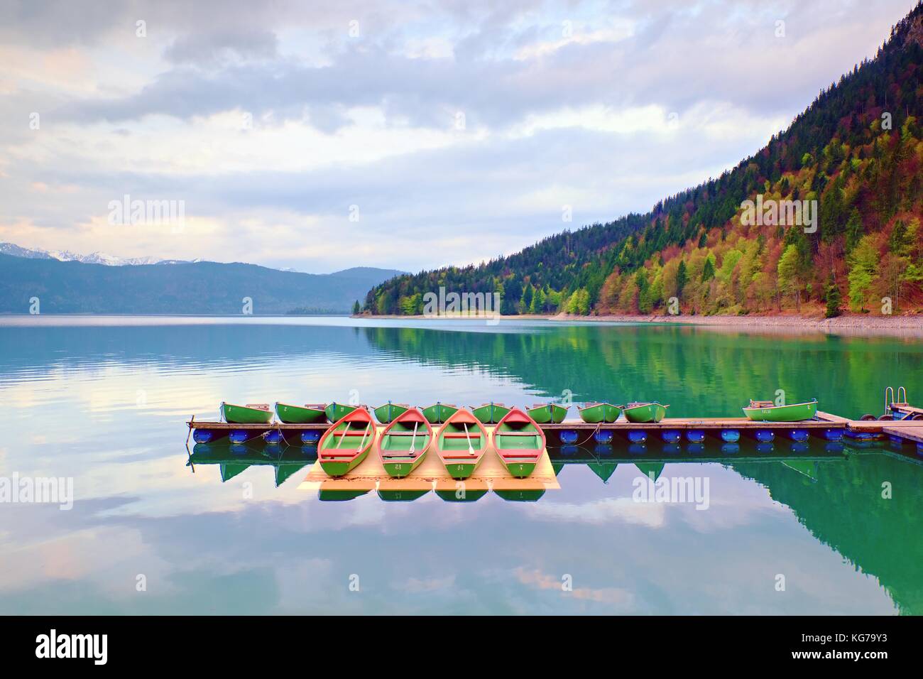 Blue Alps lake with Rental rowing boats in marina. Wharf for trip ships ...
