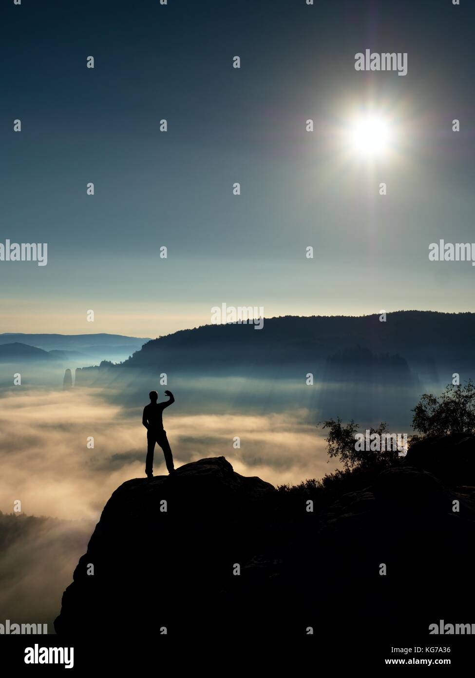 Man shadowing eyes. Alone tourist on cliff edge and watching into deep ...