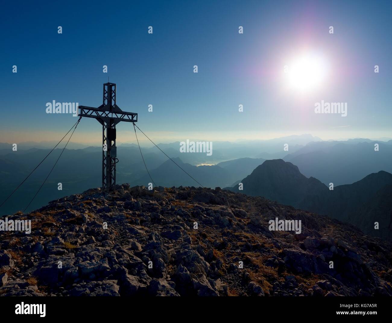 Steel crucifix at mountain peak in Alps. Sharp rocky summit, daybreak ...