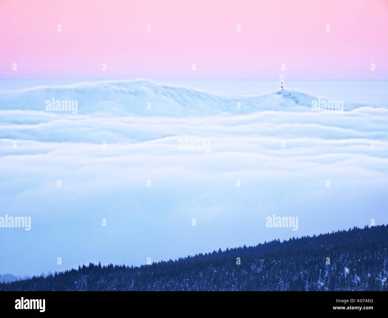 Far mountain peak with observatory above creamy mist. Shinning lights ...