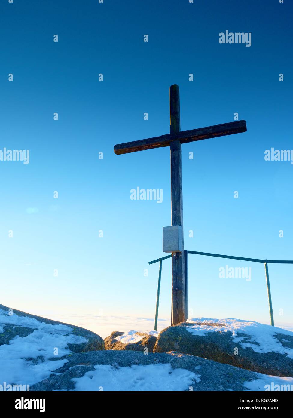 Winter mountain. Wooden cross on rocky mountain summit. Sharp peak ...