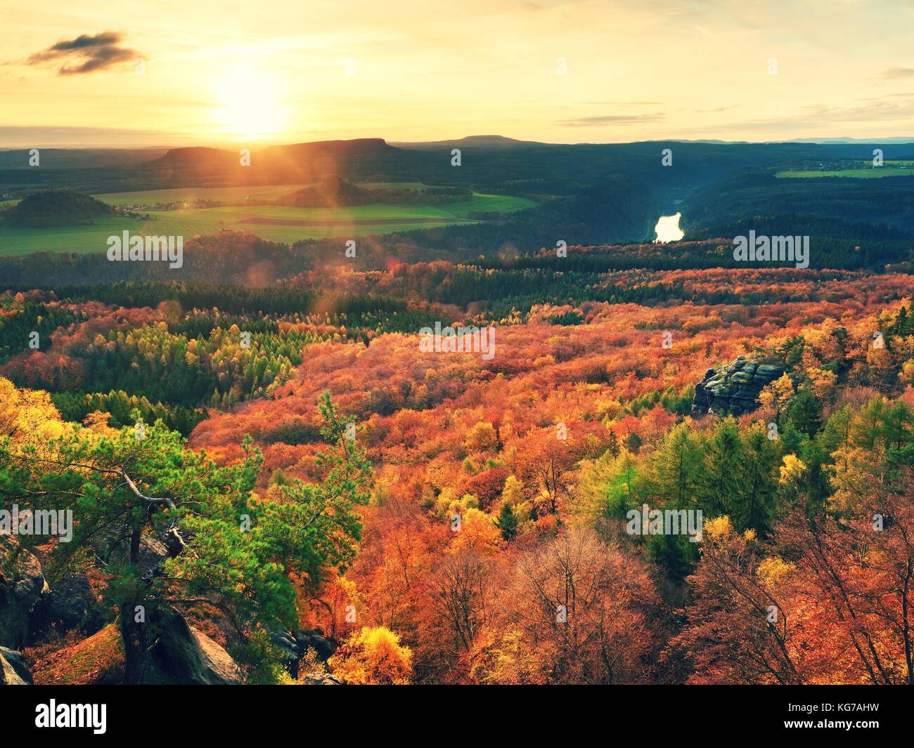View through branches to deep valley within fall afternoon. Foggy and ...