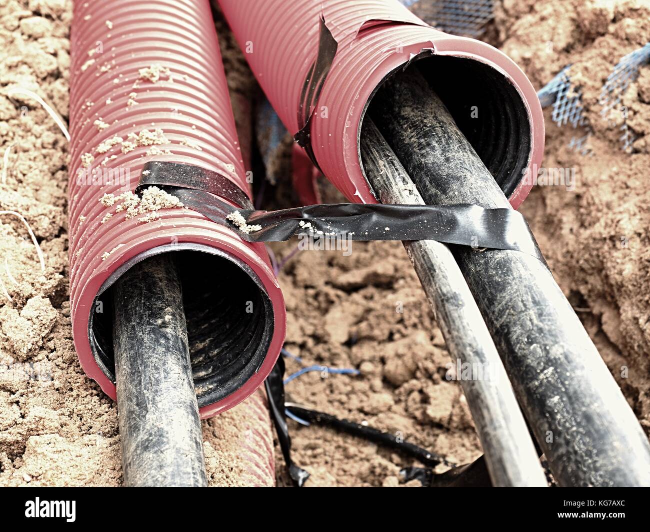 Excavation of trench with black cables in protective HDPE tube. Lines ...