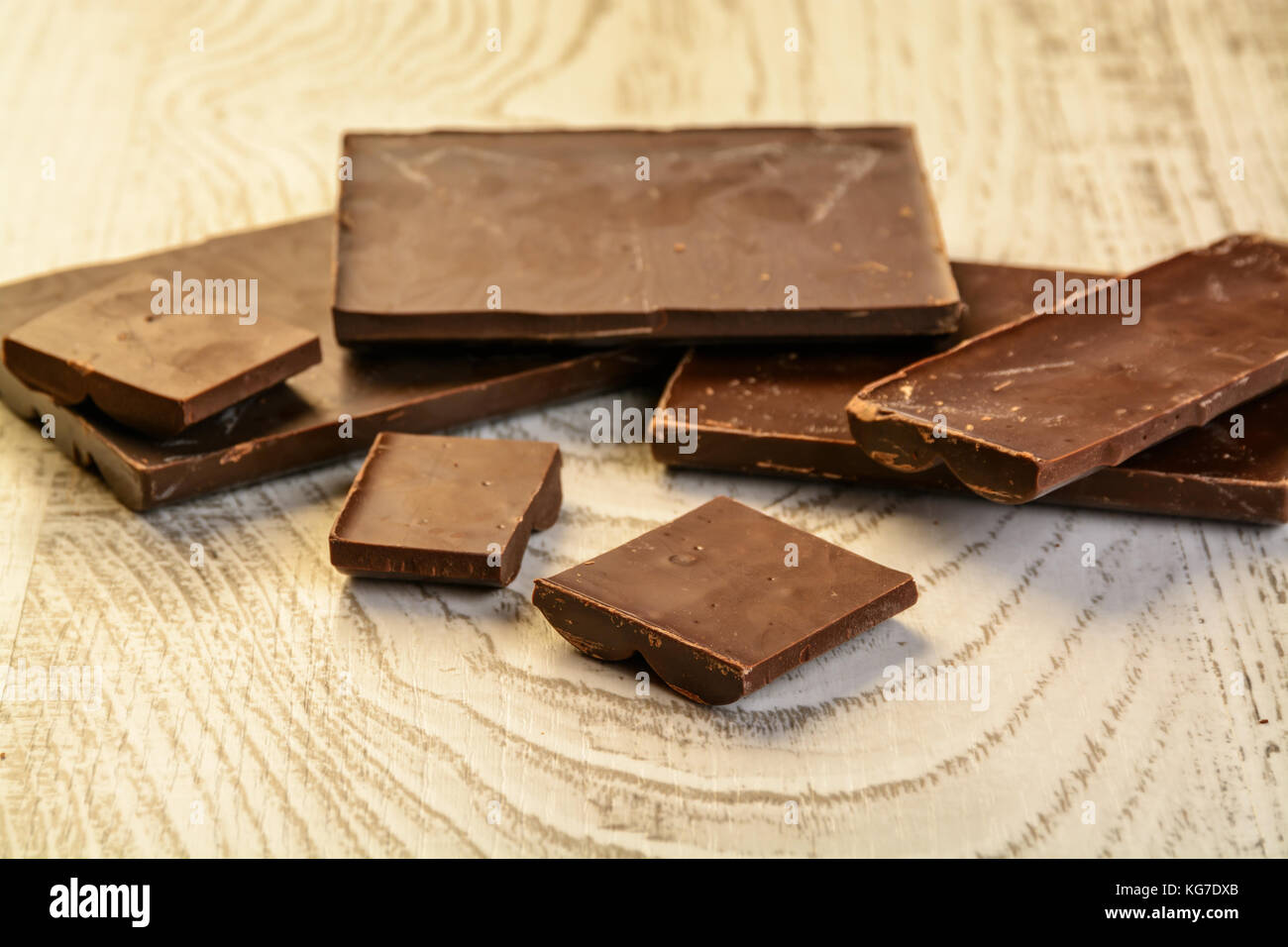 chocolate tablets with pieces on different sizes on bright wood ...