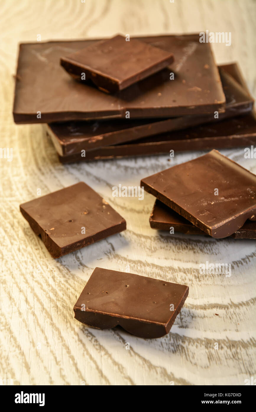 chocolate tablets with pieces on different sizes on bright wood ...