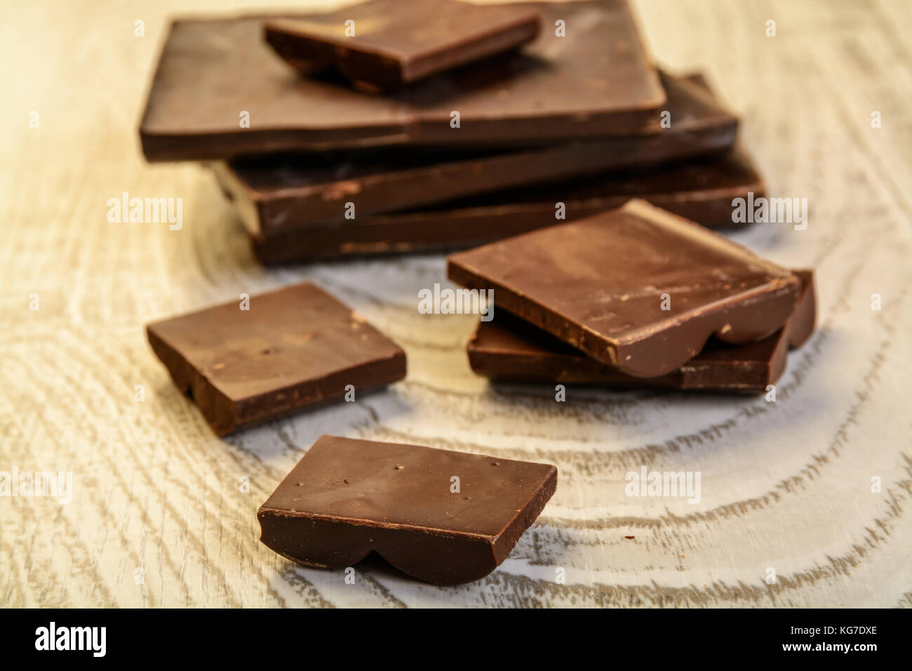 chocolate tablets with pieces on different sizes on bright wood ...