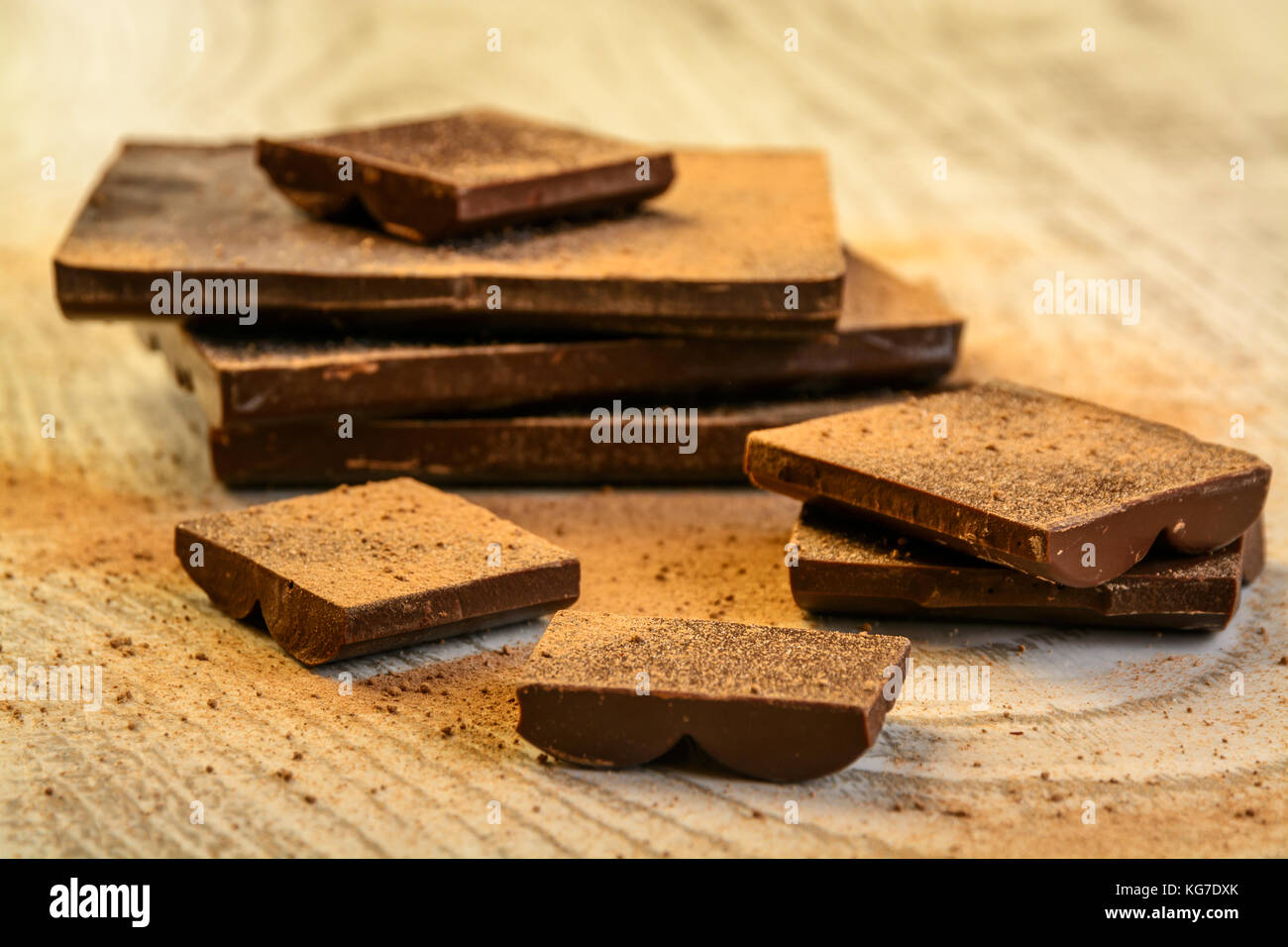 chocolate tablets with pieces on different sizes on bright wood ...