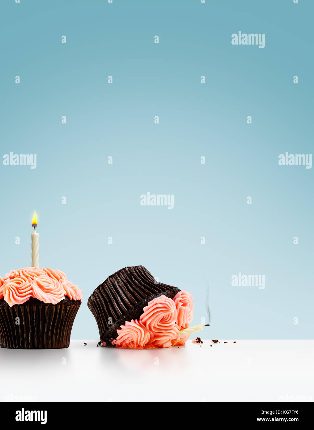 Smashed cupcake in row of cupcakes with candles on blue background ...