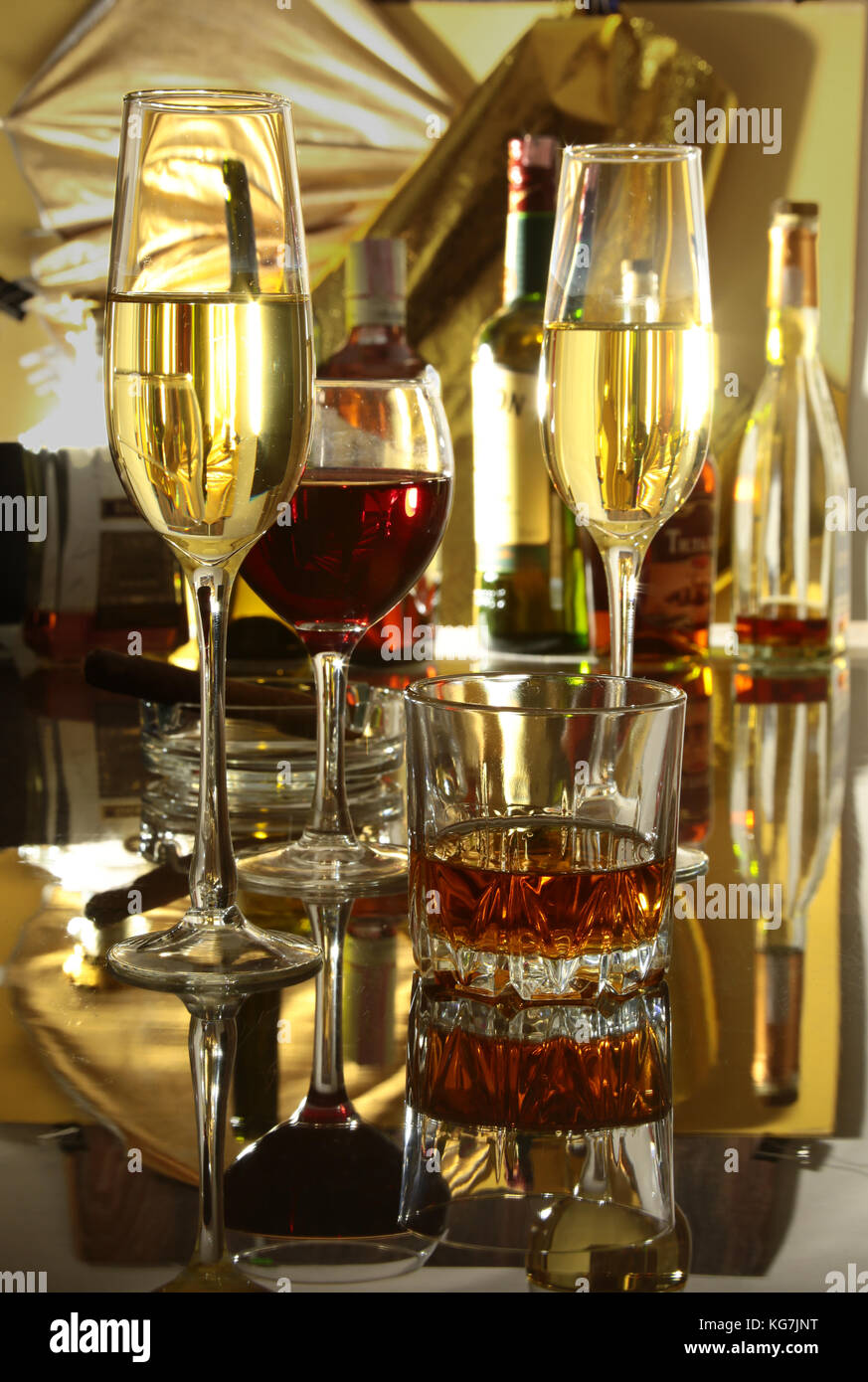 Glass of cognac, brandy or whiscy on mirror table. bottles in a bar on ...