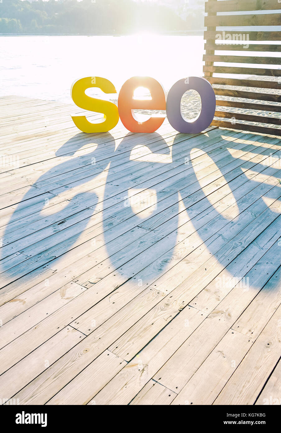 The word SEO by large colored letters creating a shadow on the wooden ...