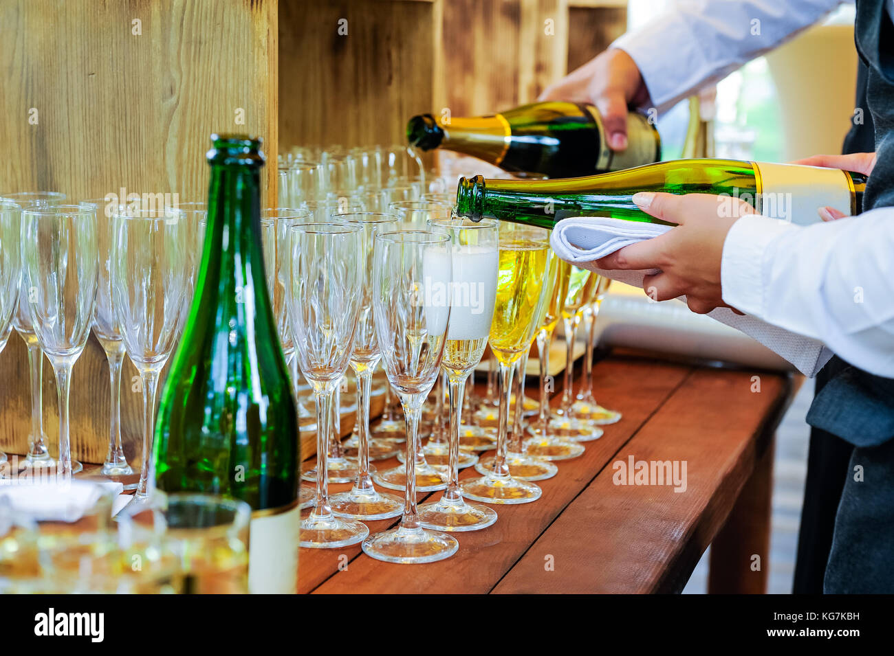 Waiter pouring personal serving Champagne in glasses. Catering service ...