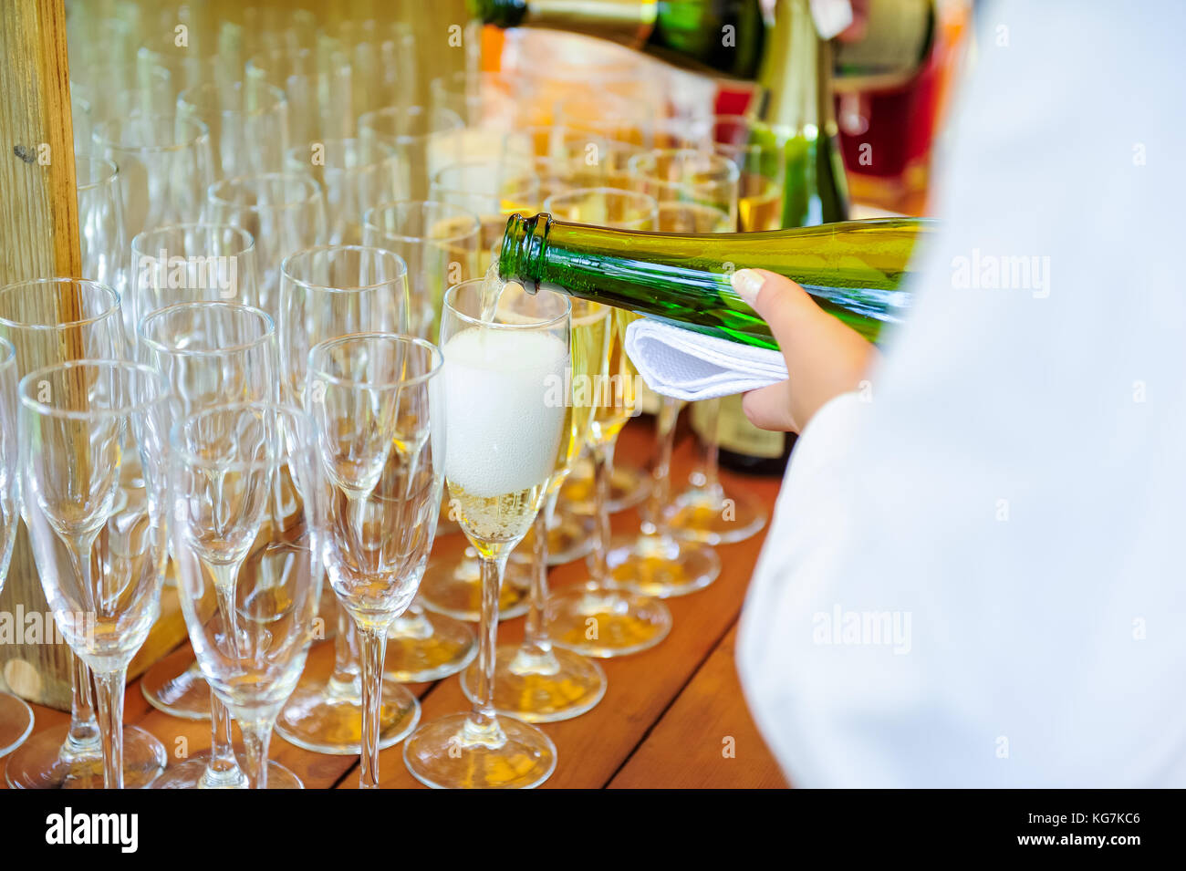 Waiter pouring personal serving Champagne in glasses. Catering service ...