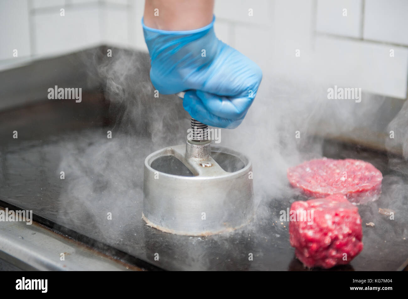 Chief cook preparing fresh burger in the kitchen.Burger restaurant menu ...