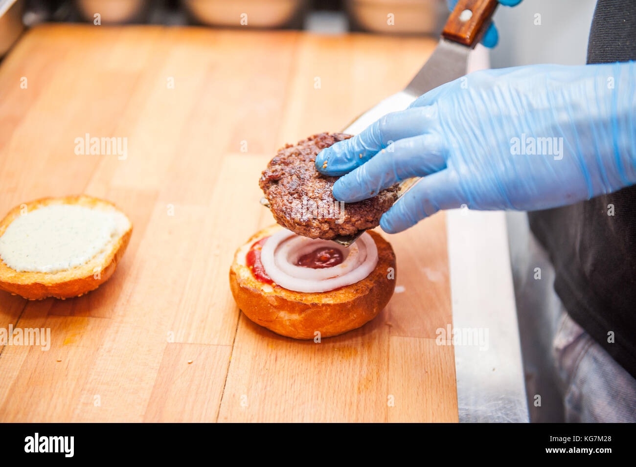 Chief cook preparing fresh burger in the kitchen.Burger restaurant menu ...
