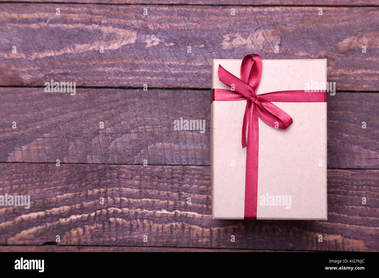 red and gold gift box on wood background Stock Photo - Alamy