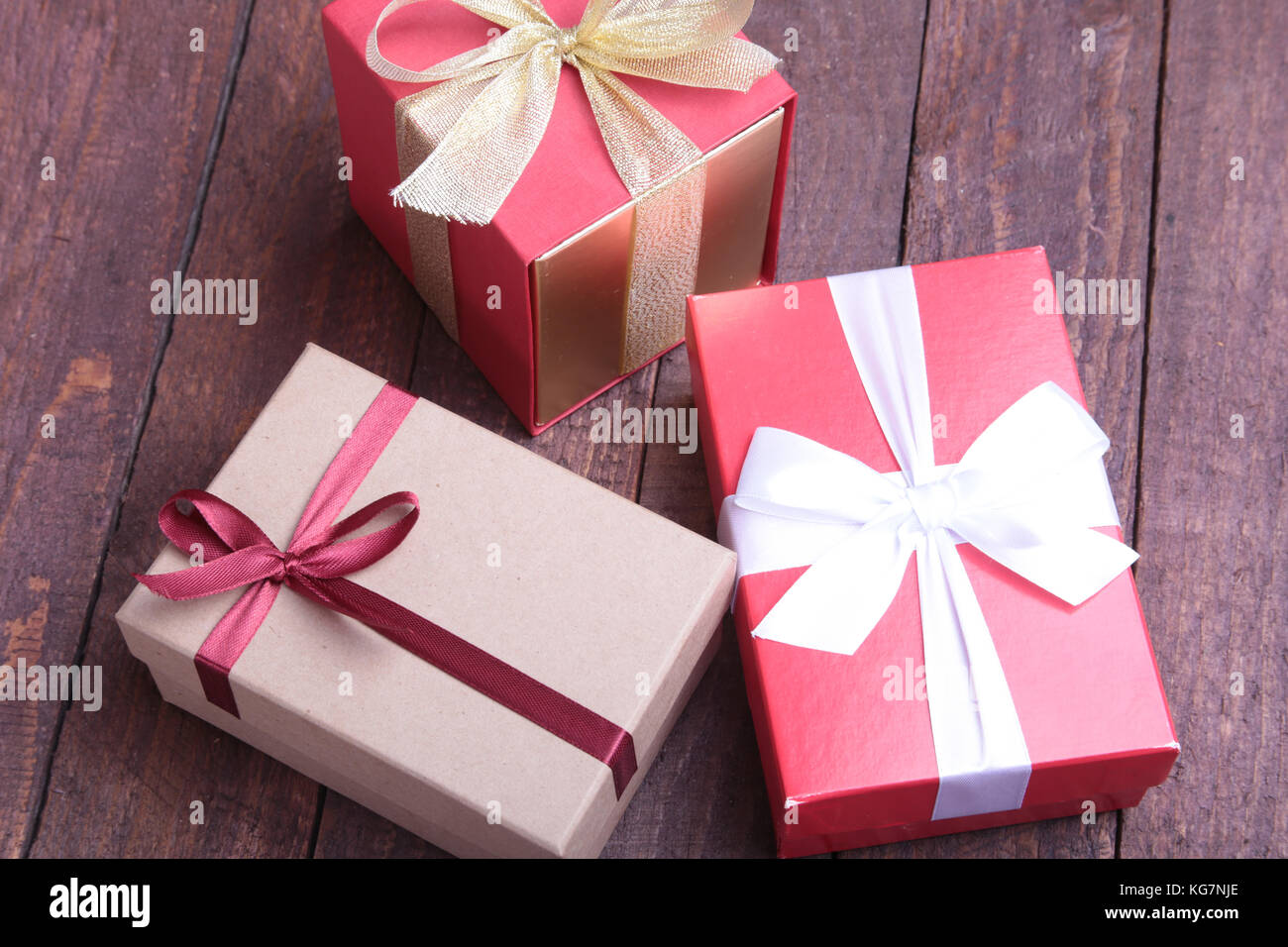 red and gold gift box on wood background Stock Photo - Alamy