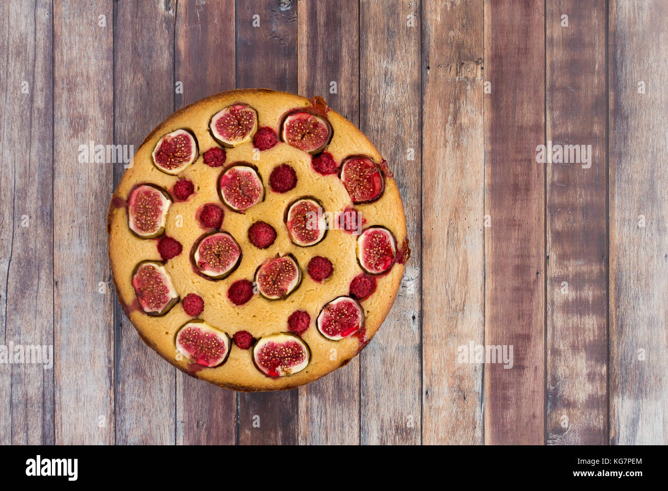 Fig and raspberry cake with almonds and a honey glaze on dark brown ...