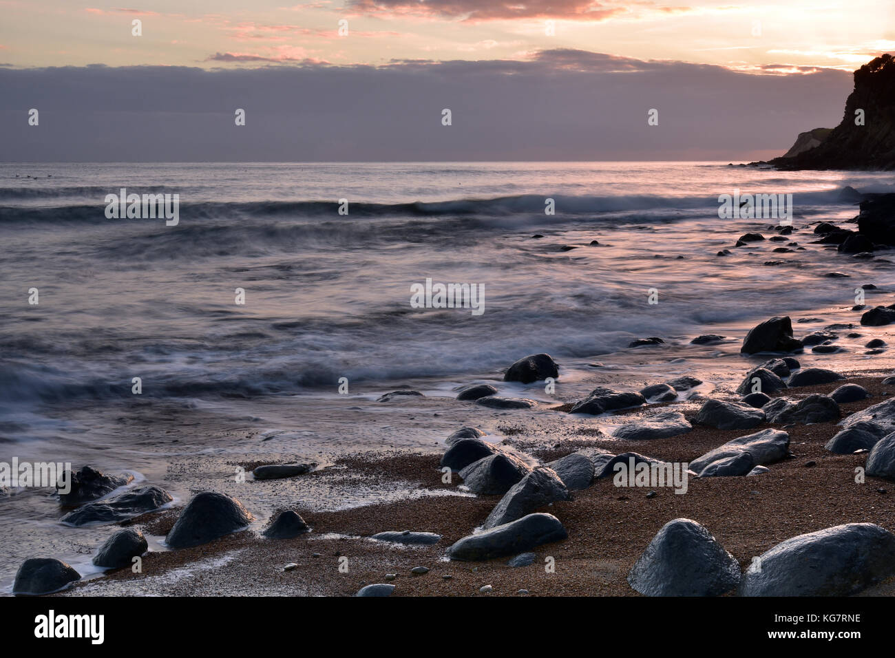 an atmospheric seascape at sunset on the isle of wight with waves ...
