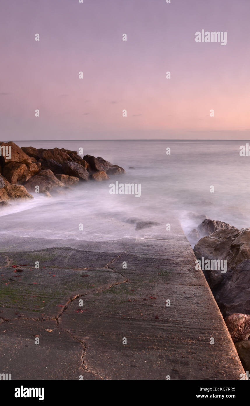 A mysterious and eerie seascape of a jetty or slipway disappearing into ...