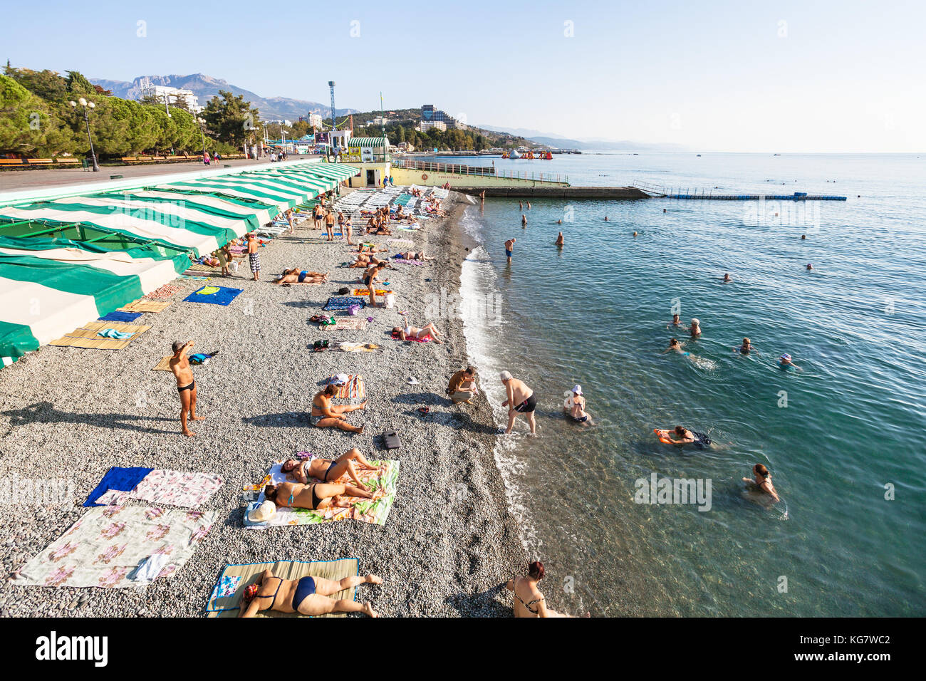 ALUSHTA, CRIMEA - SEPTEMBER 21, 2017: tourists on urban pebble beach on ...