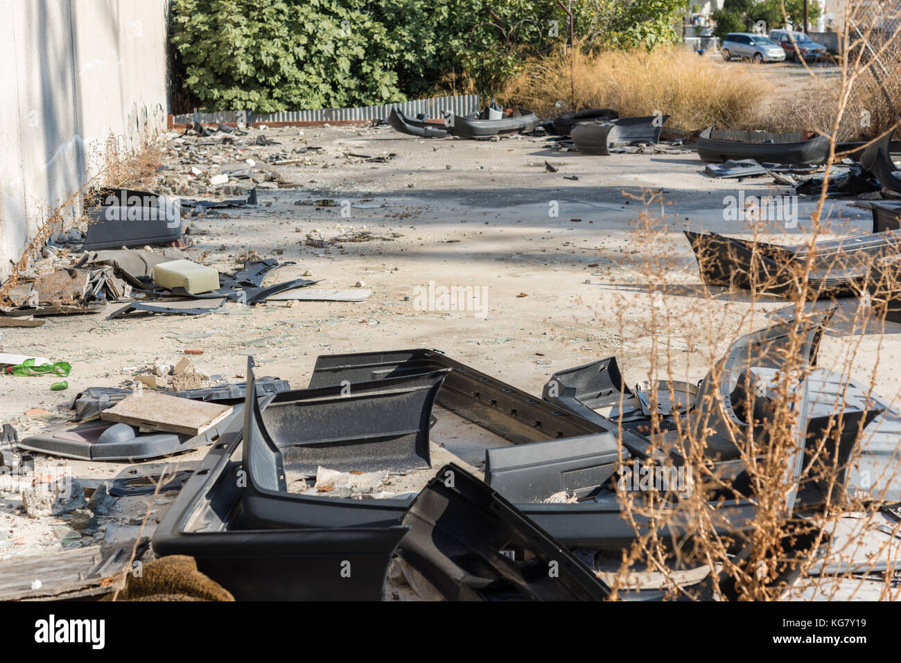 Old car bumbers and other car parts at abandoned car service building ...
