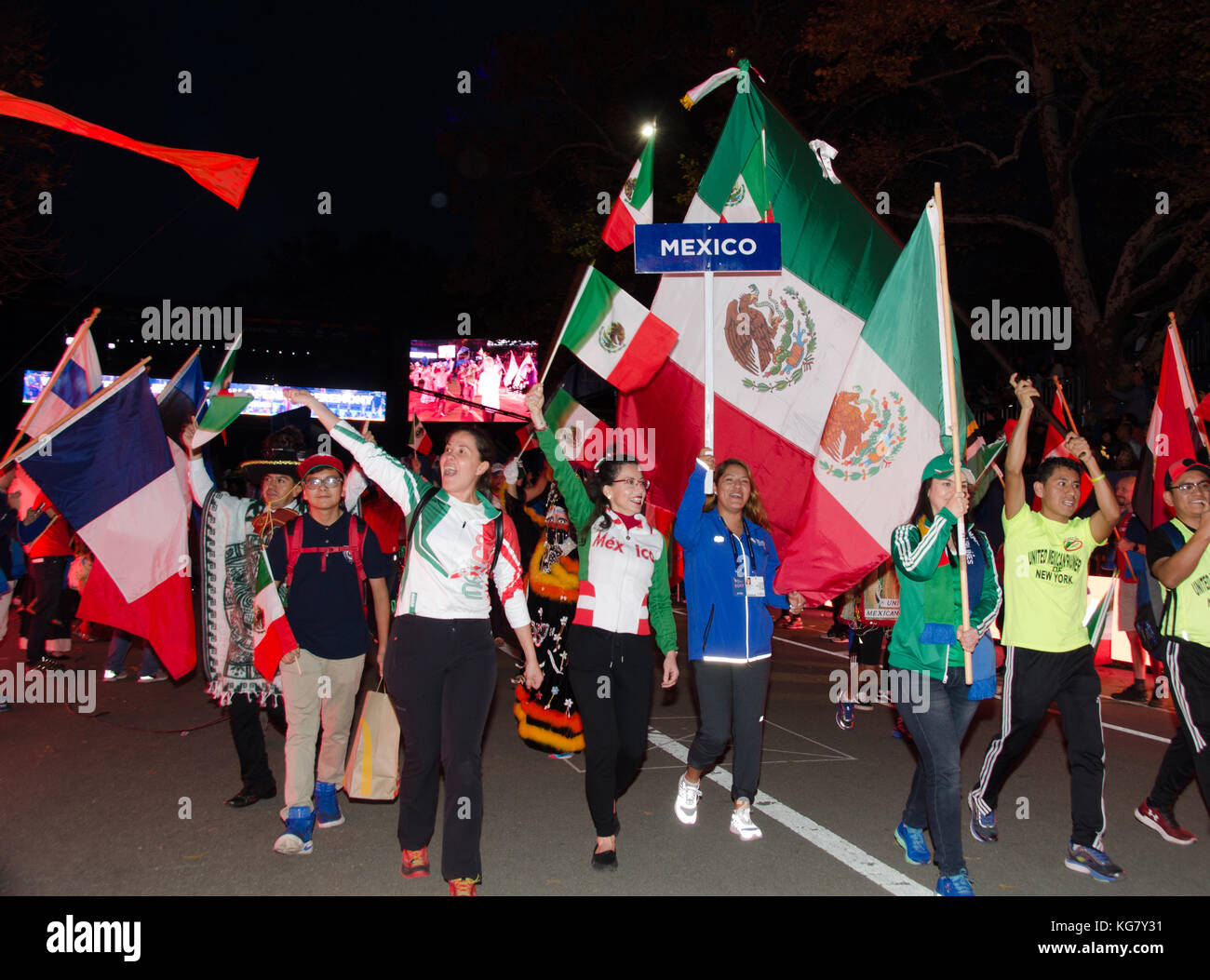 Large group of runners from Mexico waving large flags as they walk the ...