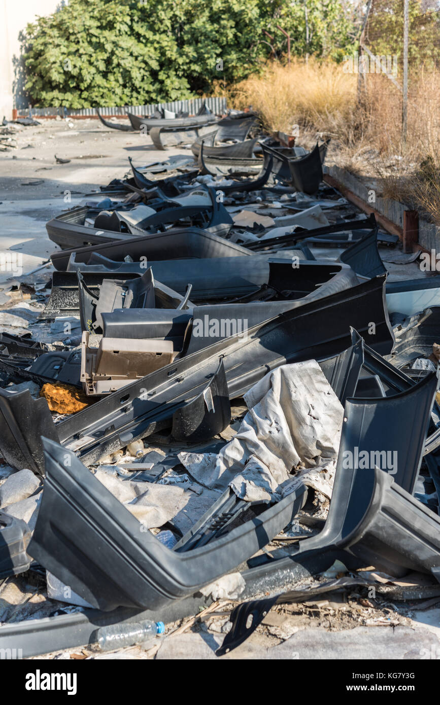 Old car bumbers and other car parts at abandoned car service building ...