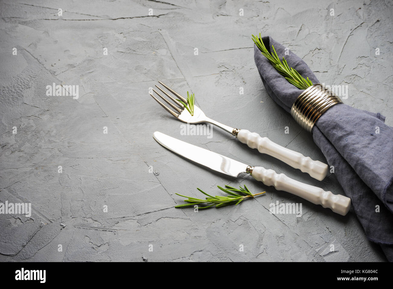 Rustic table setting with vintage tableware and rosemary herb on grey ...