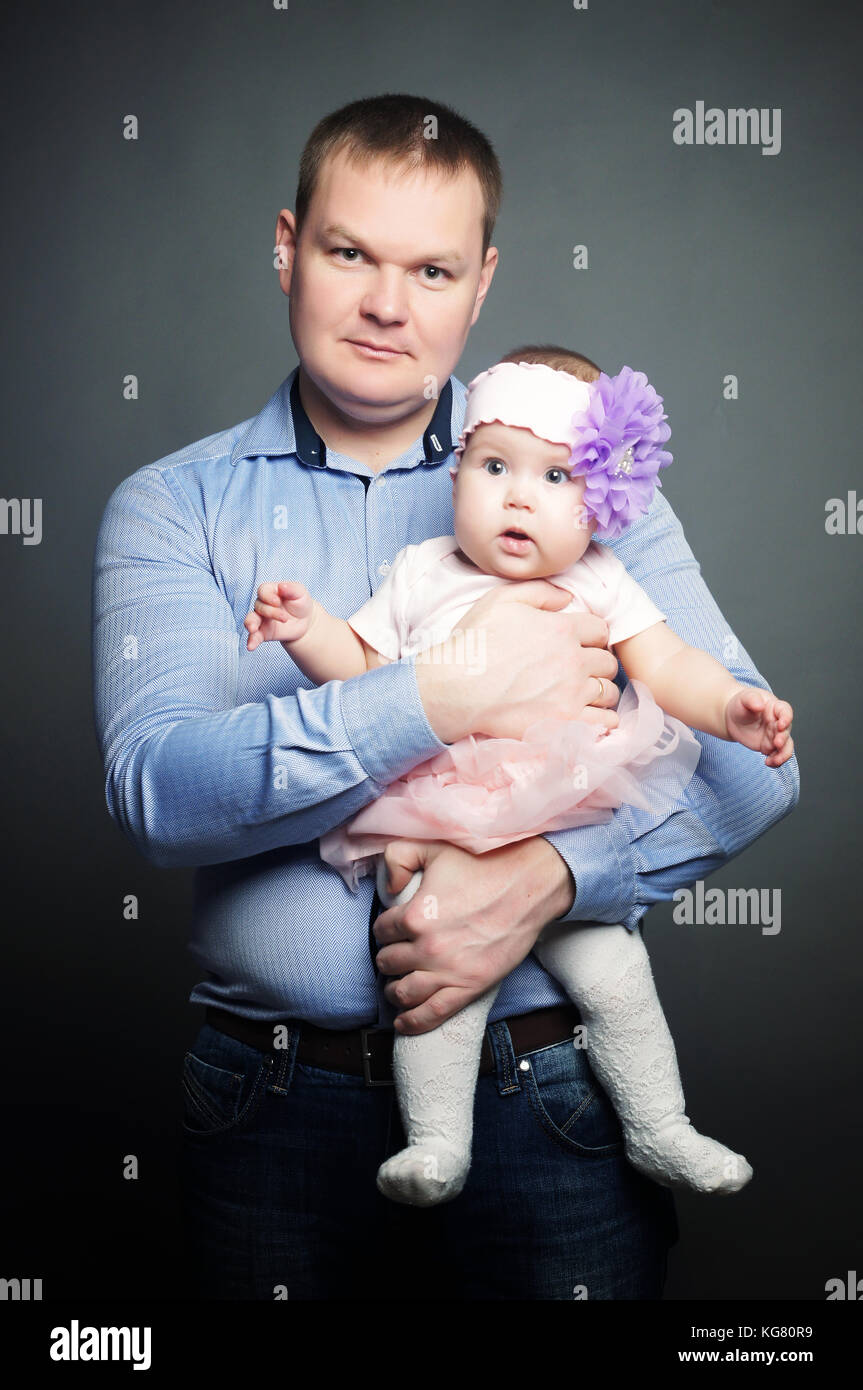man with baby in his arms posing in studio Stock Photo - Alamy