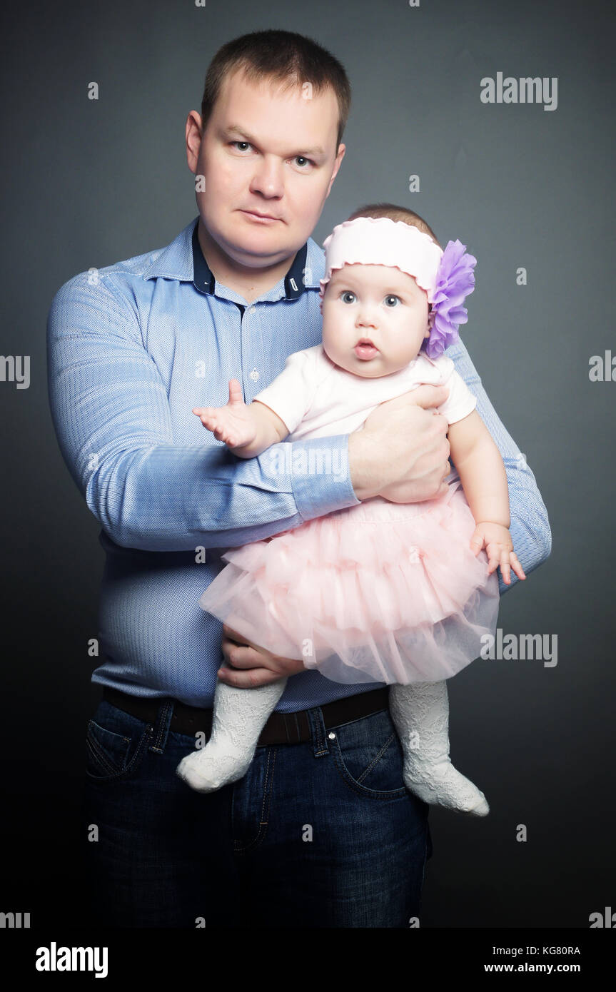 man with baby in his arms posing in studio Stock Photo - Alamy
