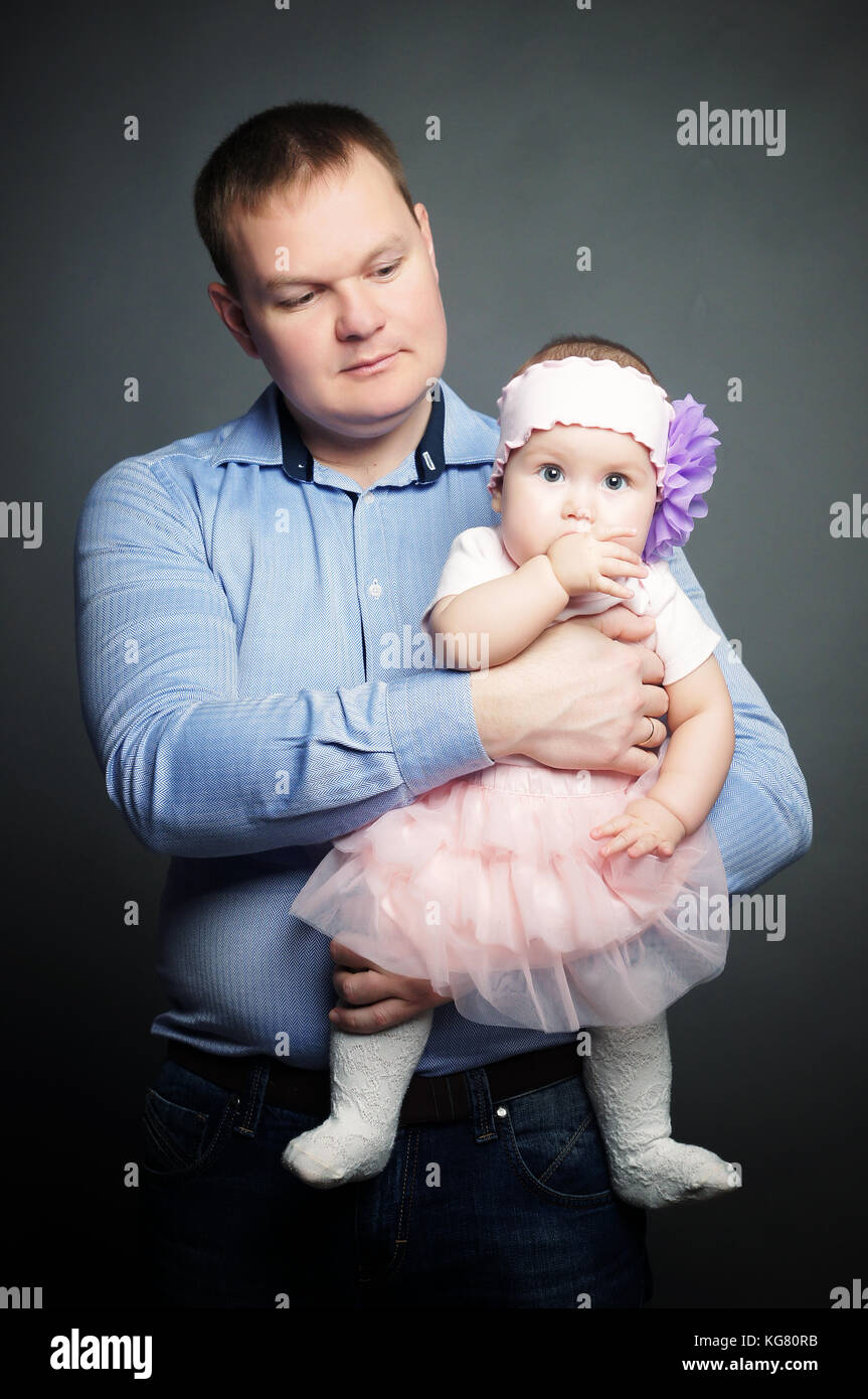 man with baby in his arms posing in studio Stock Photo - Alamy