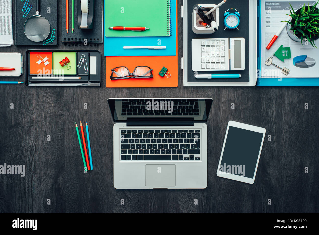 Creative business desktop with laptop, office accessories and colored ...