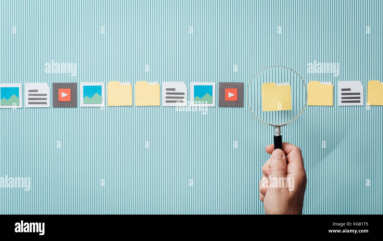 File search, scan and analysis: man zooming in on a file using a ...