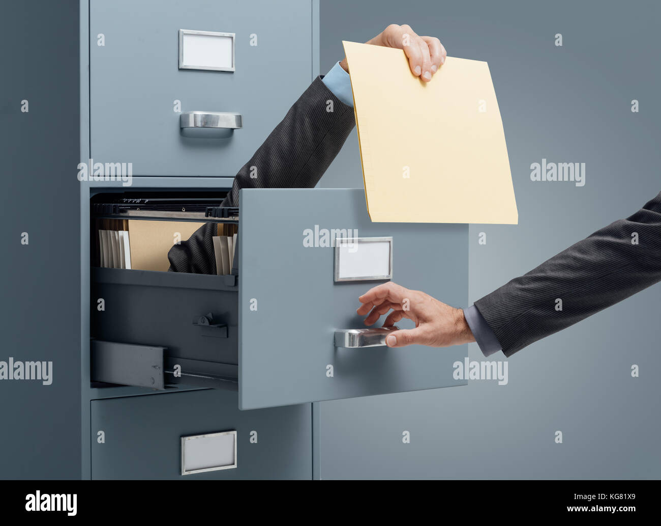 Businessman inside a filing cabinet giving a file to an office clerk ...
