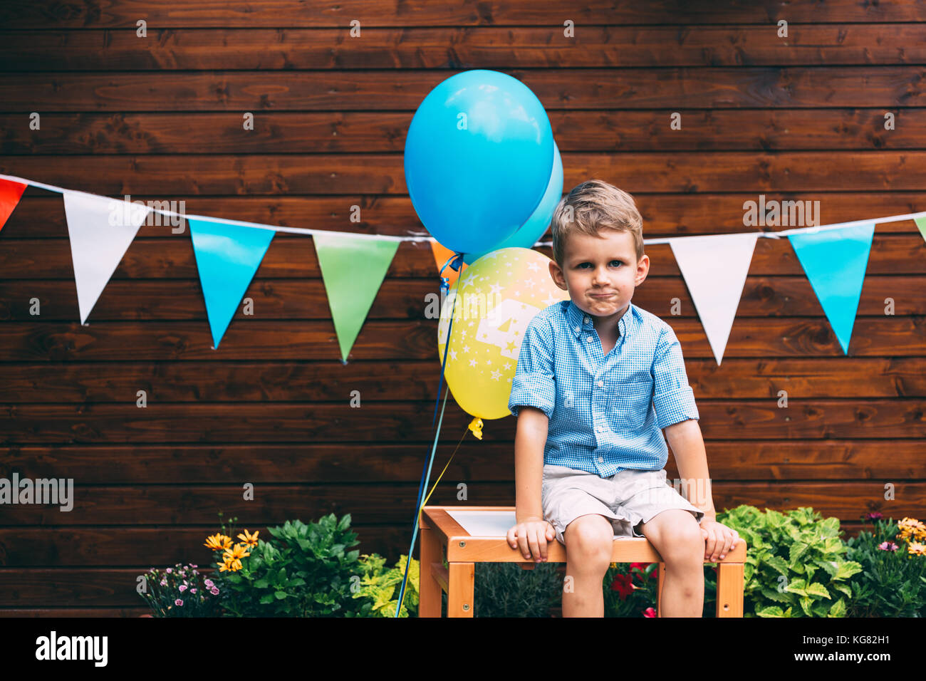 Portrait of young boy sitting on table at birthday party Stock Photo ...