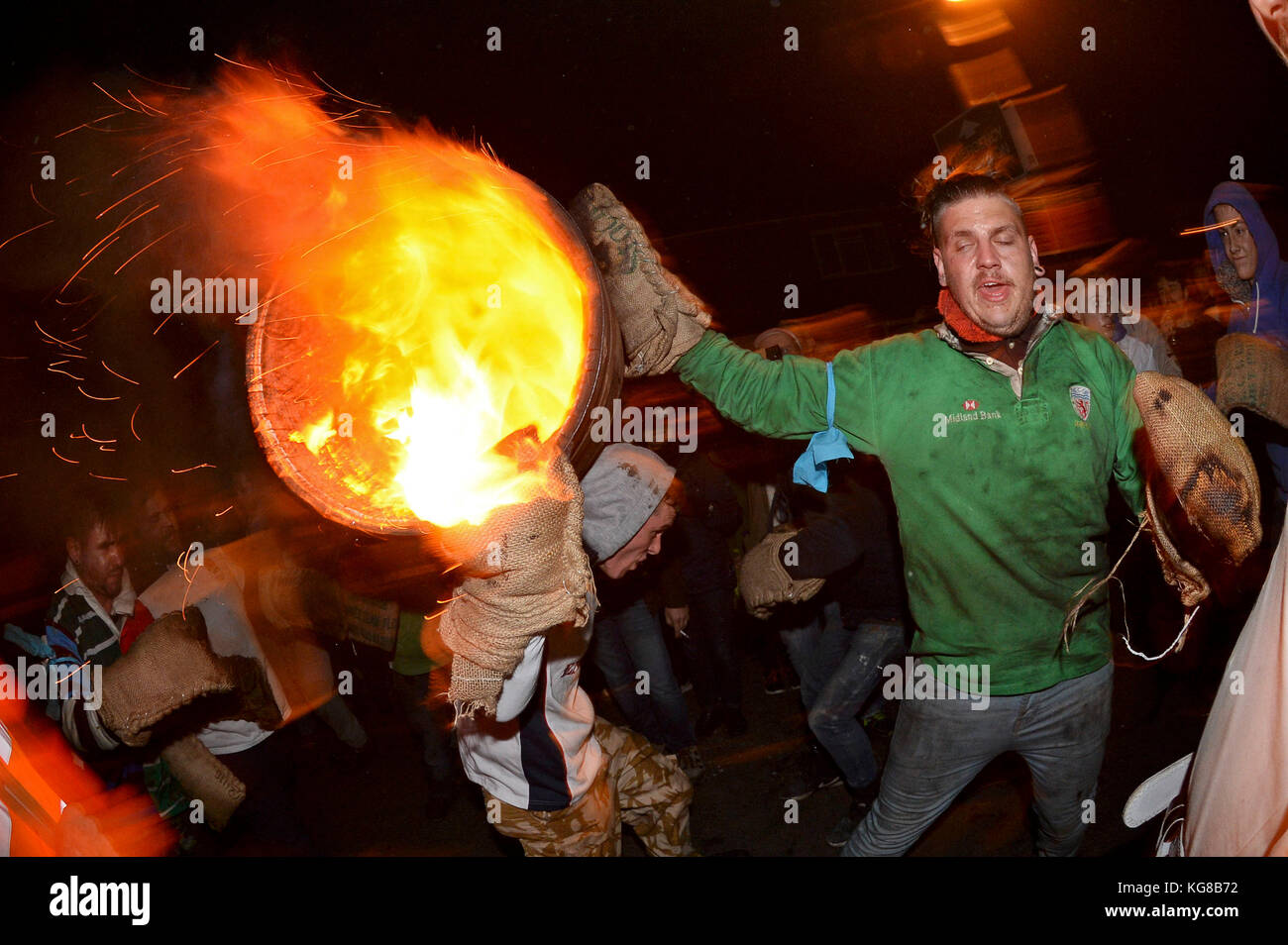 Participants run with a burning barrel soaked in tar at the annual ...
