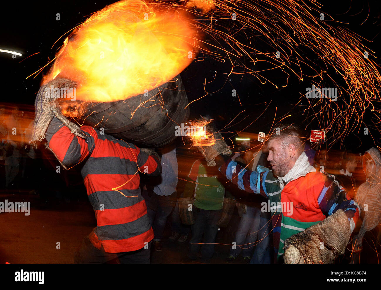 Participants run with a burning barrel soaked in tar at the annual ...