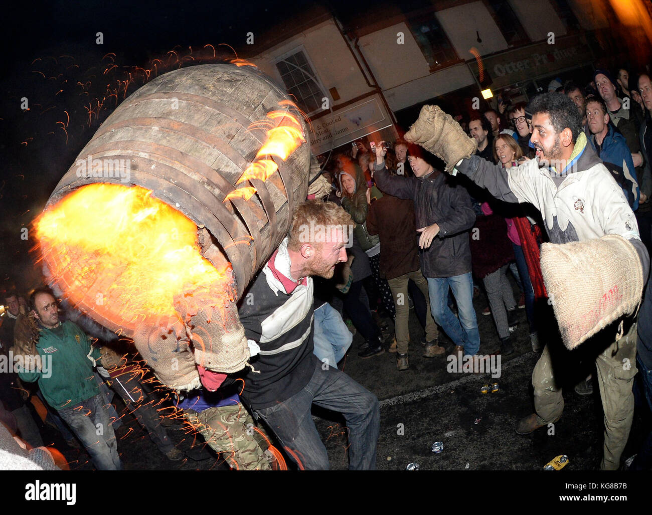 Participants run with a burning barrel soaked in tar at the annual ...