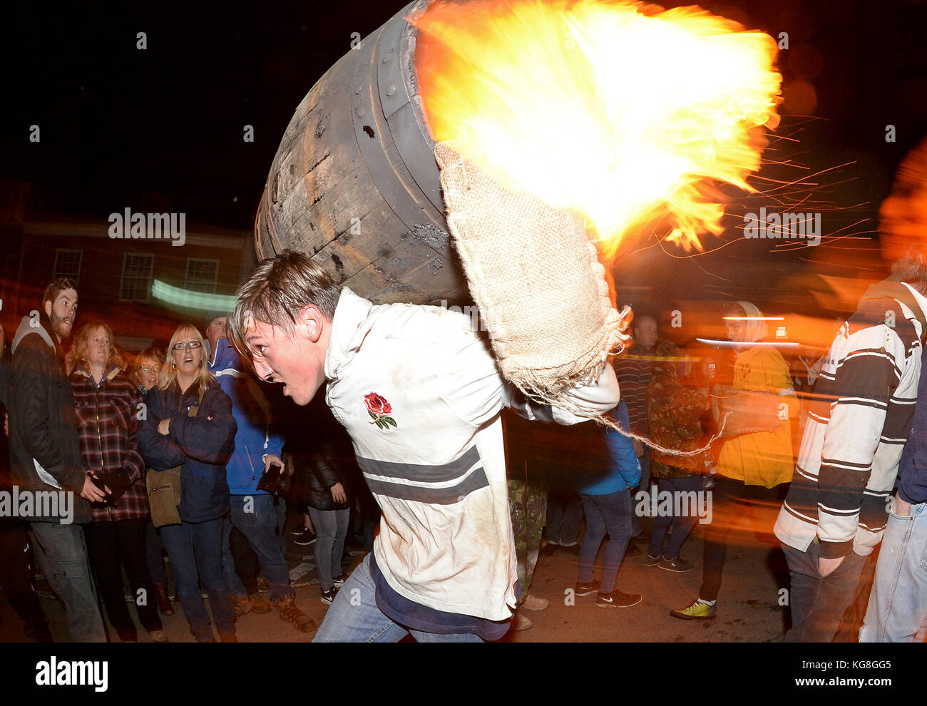 Participants run with a burning barrel soaked in tar at the annual ...