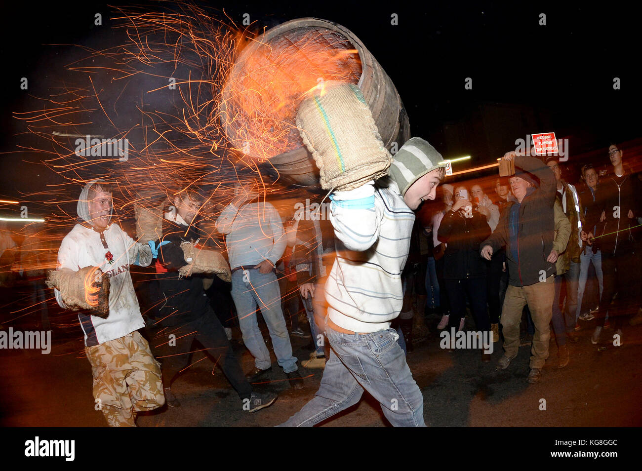 Participants run with a burning barrel soaked in tar at the annual ...