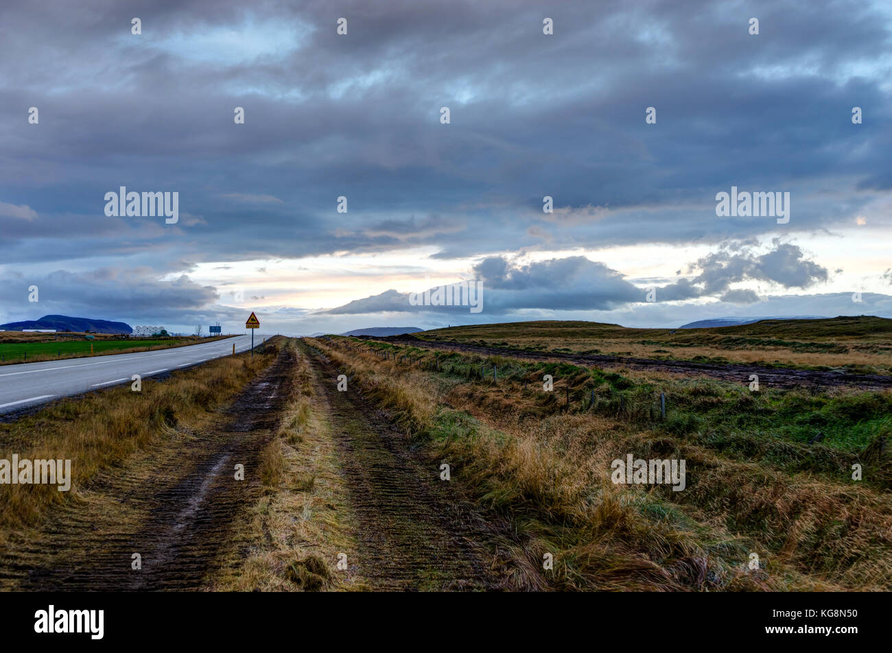 Empty street with cloudy sky and Icelandic Landscape during Sunr Stock ...