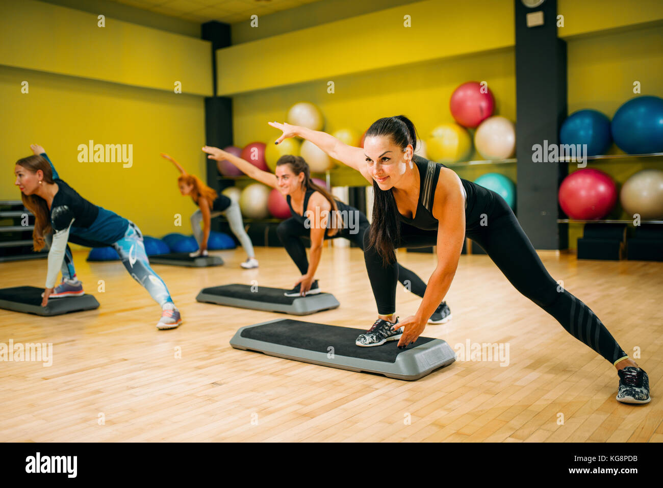 Women group on step aerobic training. Female sport teamwork in gym. Fit ...