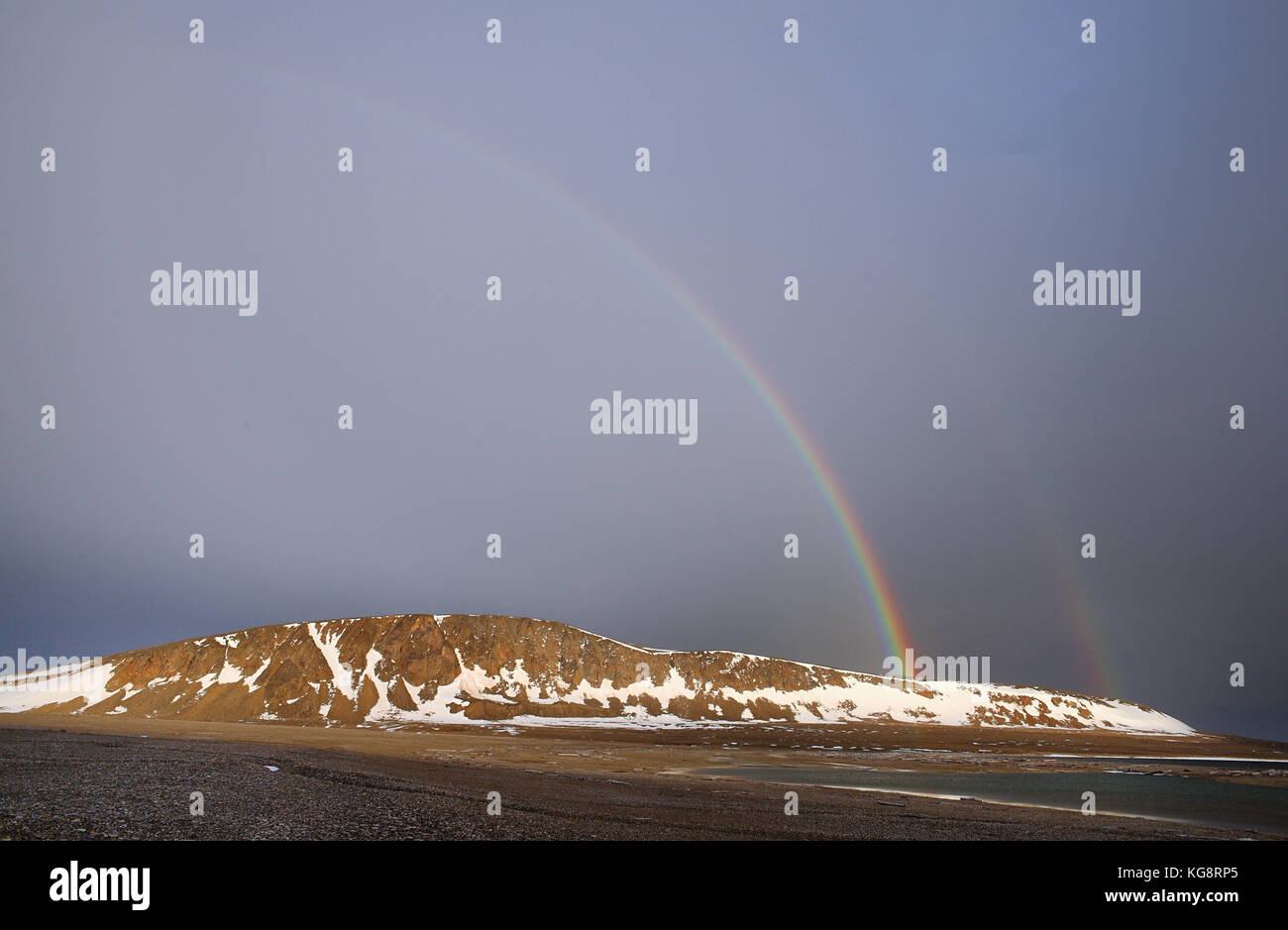 Summer arctic landscape with double rainbow over sea and mountains ...