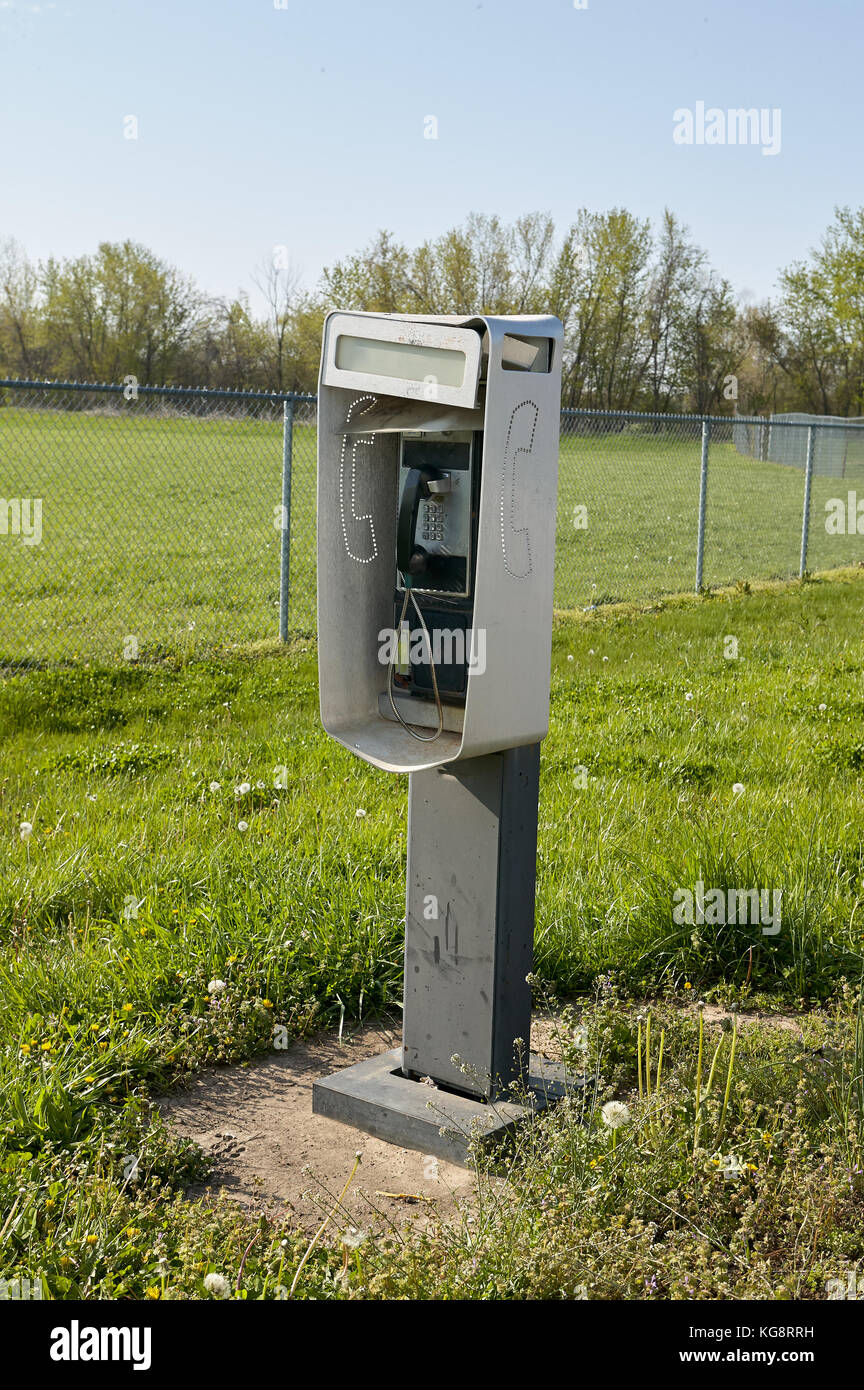 Outdoors freestanding public phone booth in a lush green field or ...