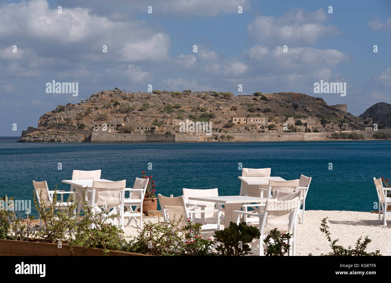 Tables and chairs overlook Spinalonga Island from Plaka a northern ...