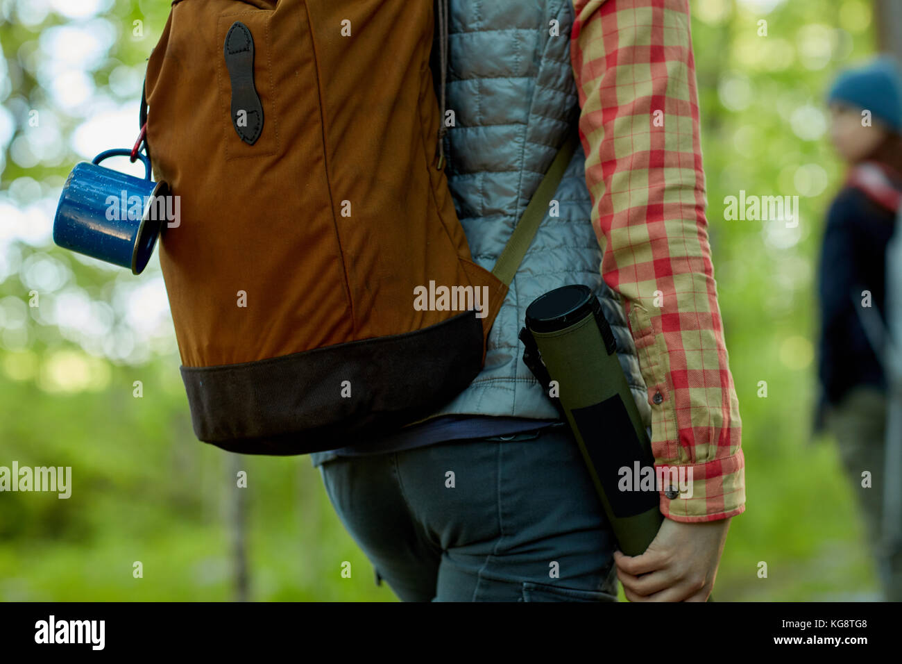 Female backpacker hiking with a friend through woodland in a close up ...