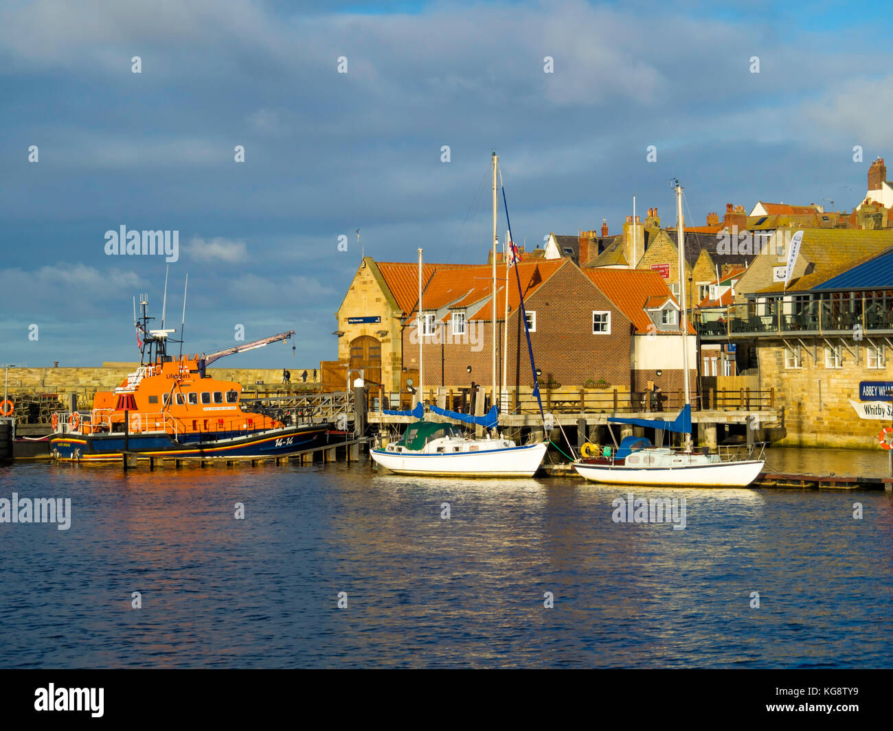 Whitby harbour with the lifeboat station, two moored pleasure sailing ...
